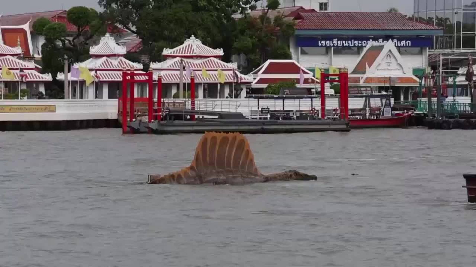 Un Spinosaurus nada en el río Chao Phraya en Bangkok, como parte de la promoción de 'Jurassic ...